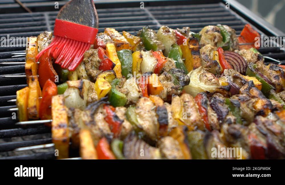 Slow Motion of chef covering with sauce the delicious skewers on BBQ ...