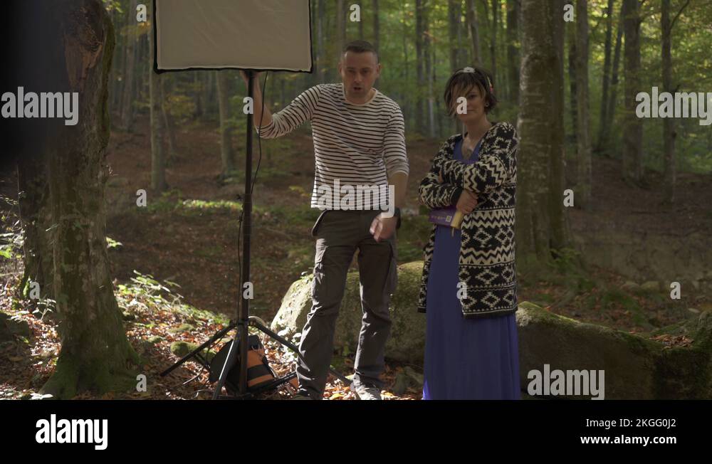 Photographer showing position to female model during photo session in ...