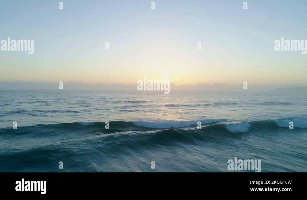 Forward flight over water and beautiful waves rising high up facing the ...