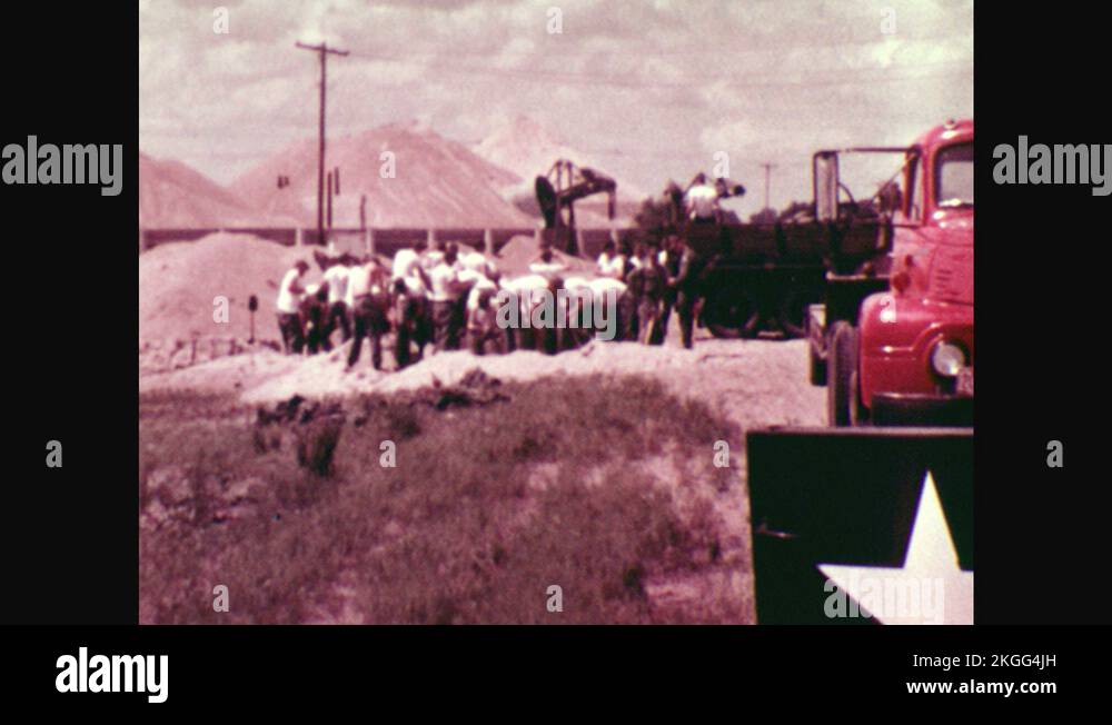 1970s: Group of soldiers digging and filling sandbags. Soldiers pile ... 1970s: Group of soldiers digging and filling sandbags. Soldiers pile ...