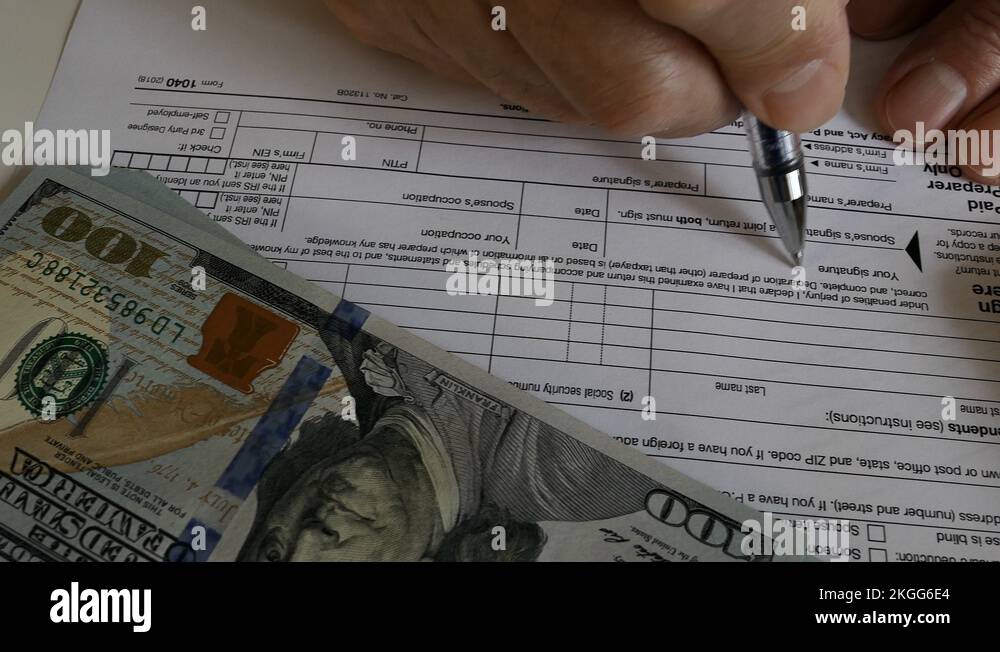 An Elderly Man Signs Irs Us Individual Income Tax Form 1040. Calculator ...