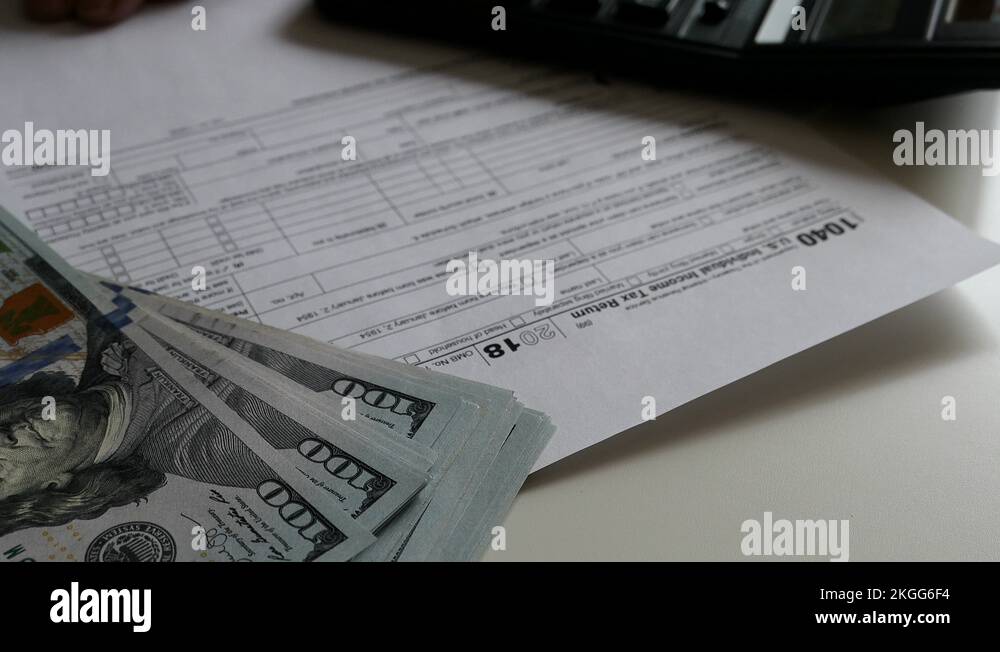 An Elderly Man Signs Irs Us Individual Income Tax Form 1040. Calculator ...