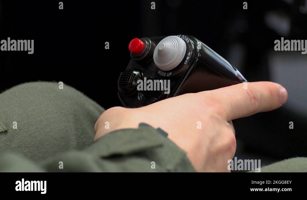 Trainee pilot operating joystick of virtual reality flight simulator ...