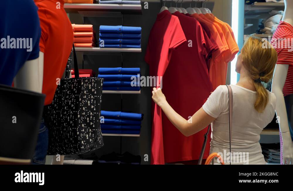 concept of sale, fashion, consumerism woman choosing clothes in mall ...