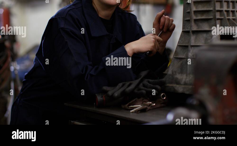 4K Portrait smiling female engineer working on an engine in a factory ...