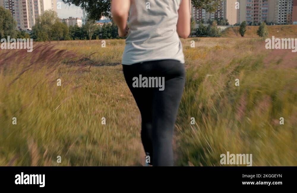 Close-Up Woman Runnig Follow Shot.Beauty Girl Running On Green Grass ...
