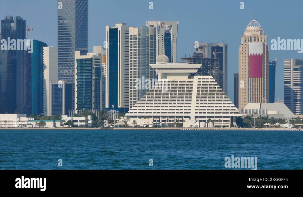 A big flag of Qatar on Doha downtown and skyscrapers with gulf - Middle ...