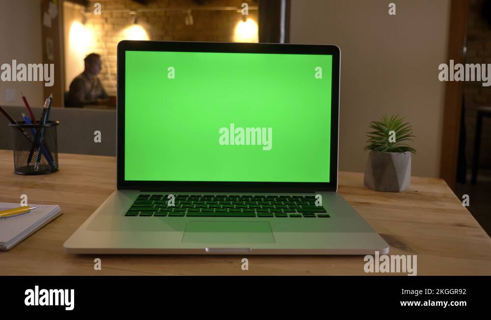 Closeup shoot of a green screen of the laptop lying on the desk in ...