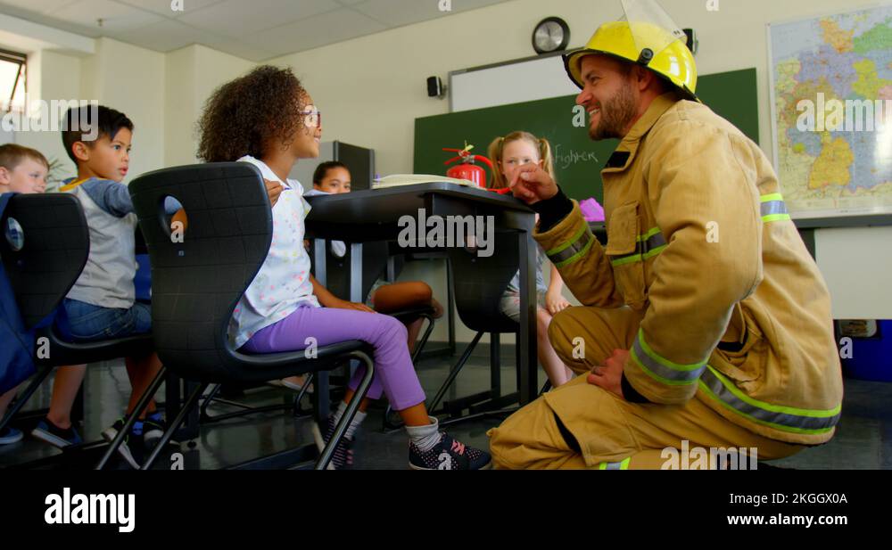 Young handsome Caucasian male firefighter teaching schoolgirl about ...