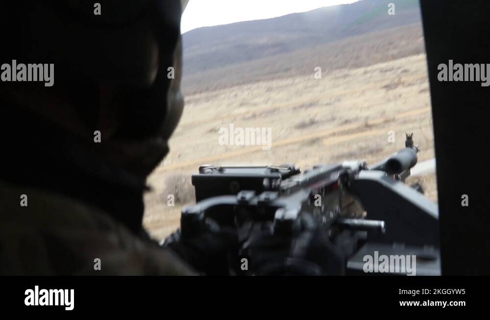 Door gunner firing machine gun from helicopter at Novo Selo Range ...