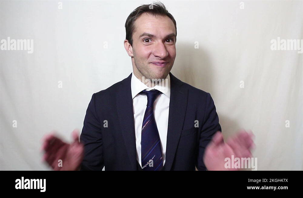 Handsome young businessman actively expresses joy clapping and loud ...
