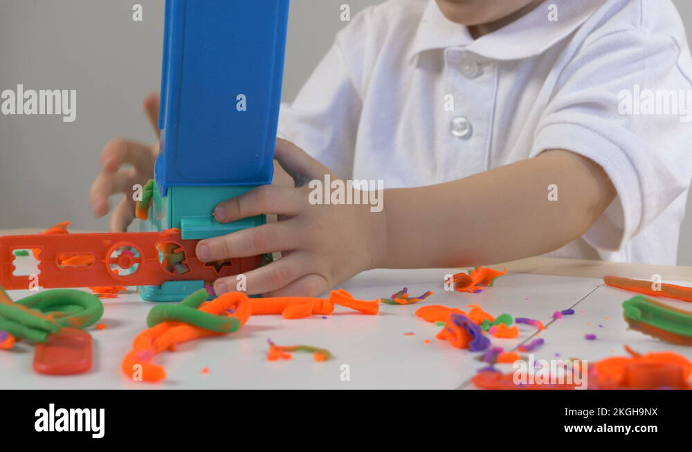 A 2-year-old preschool kid playing with modeling clay (compound Stock ...