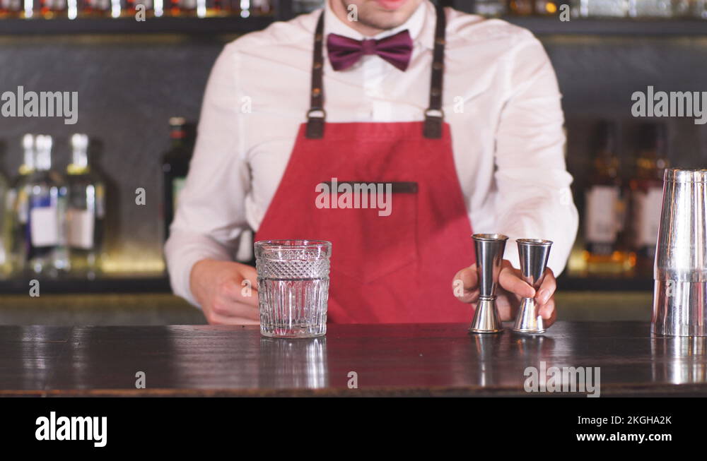 Bartender adding ice crumbs into an empty cocktail glass on the bar counter at Stock Video ...