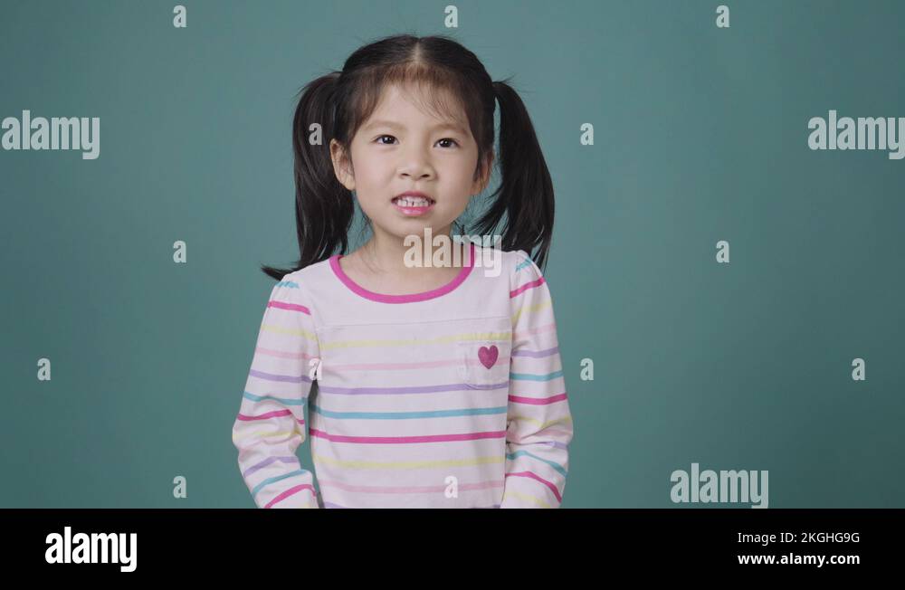 Portrait of little asian girl sing a song and clapping her hand over ...