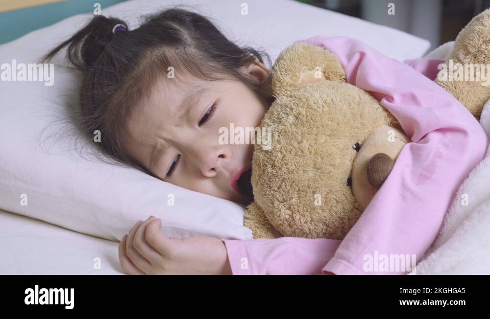 Little asian girl crying with her teddy bear have the tears on her face ...