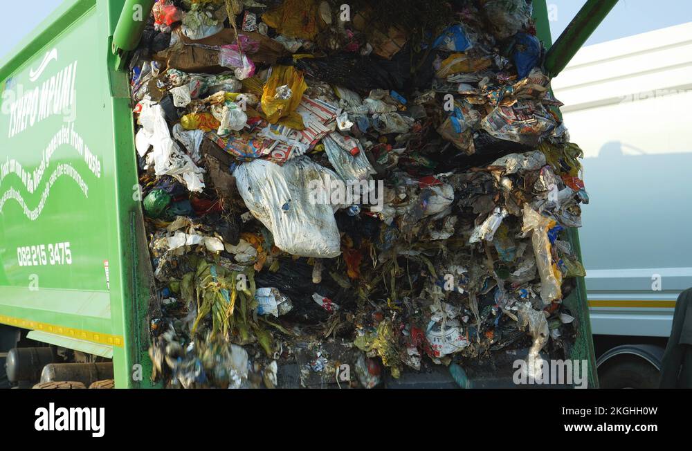 4K close-up view of trash being dumped by a garbage truck at a landfill ...