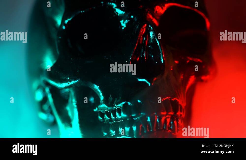 Shining skull head rotates from left to right on dark smoke background ...