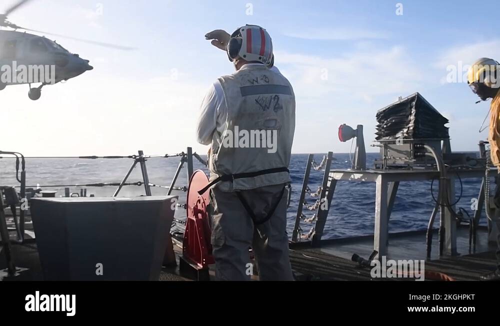 USS Curtis Wilbur flight deck crew signalling to MH-60 Seahawk ...