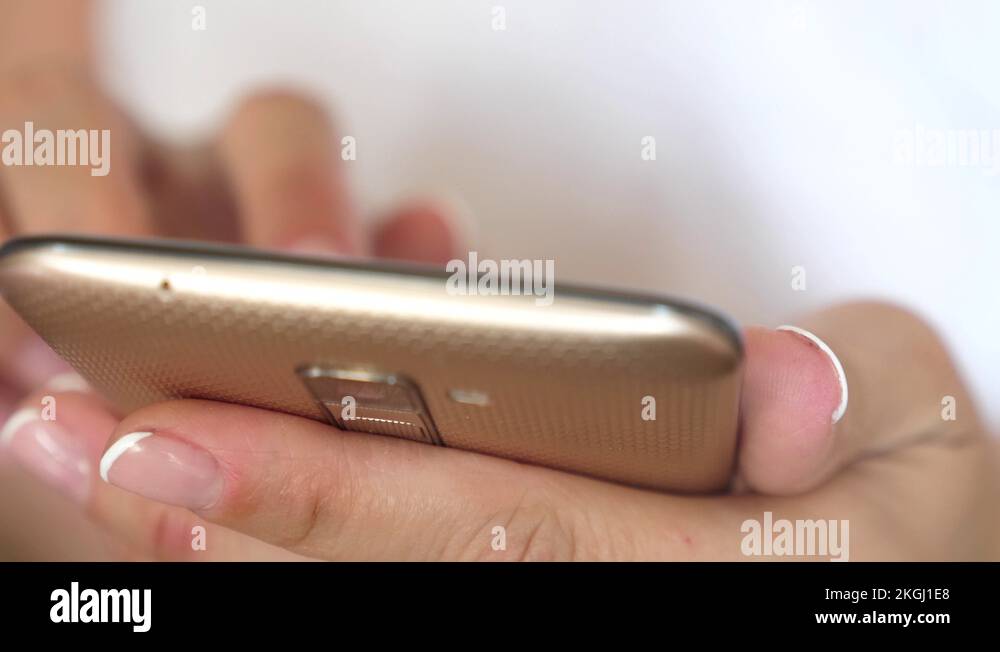A girl's hand is typing a mobile message on the smartphone screen ...