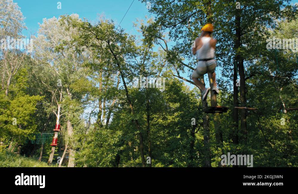 Man in Helmet is Sliding Down ZipLine in Adventure High Rope Park in ...