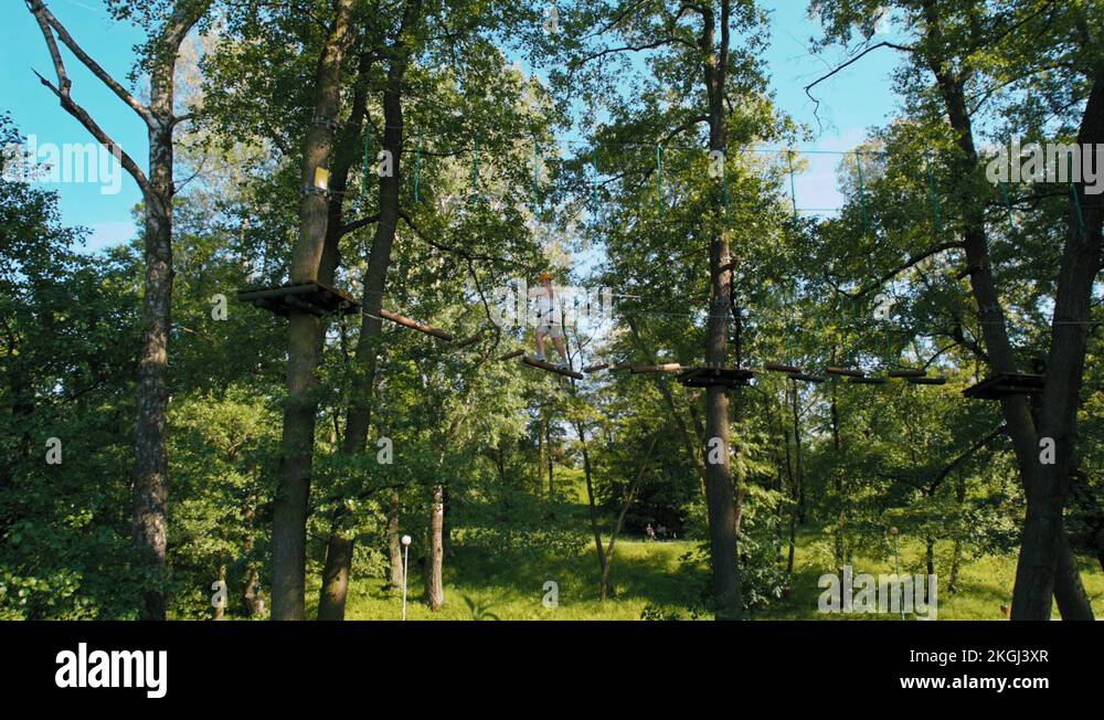 Man in Adventure Rope Park Doing Climbing Exercises on Balance Beam in ...