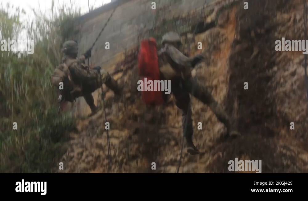 Two American soldiers descending from a natural wall as a rappel ...