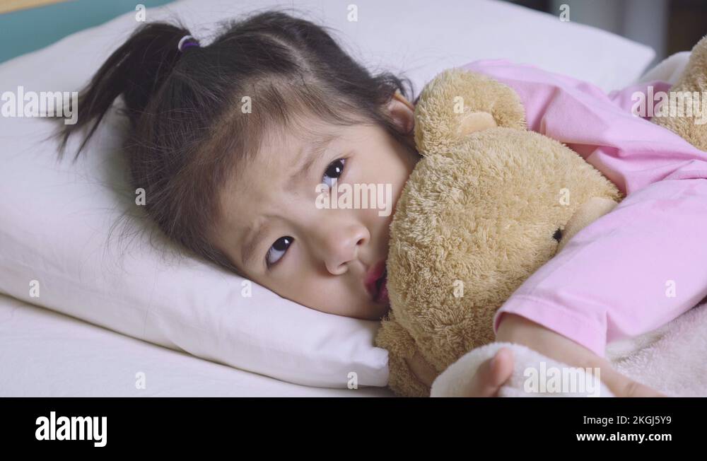 Little asian girl crying with her teddy bear have the tears on her face ...