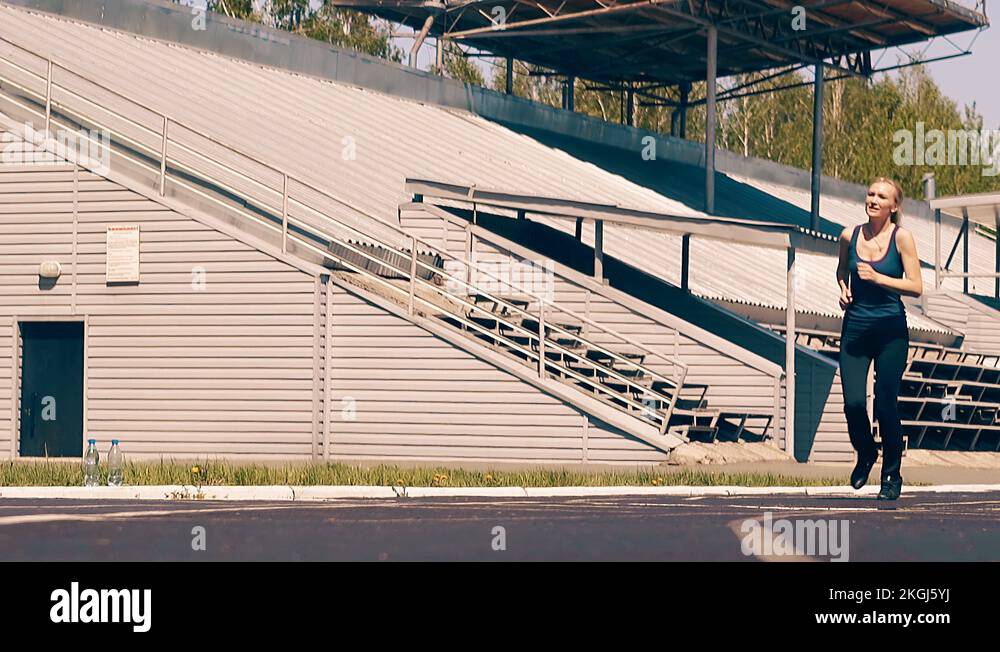 Slow motion: Young cute girl, sporty physique, performs easy run ...