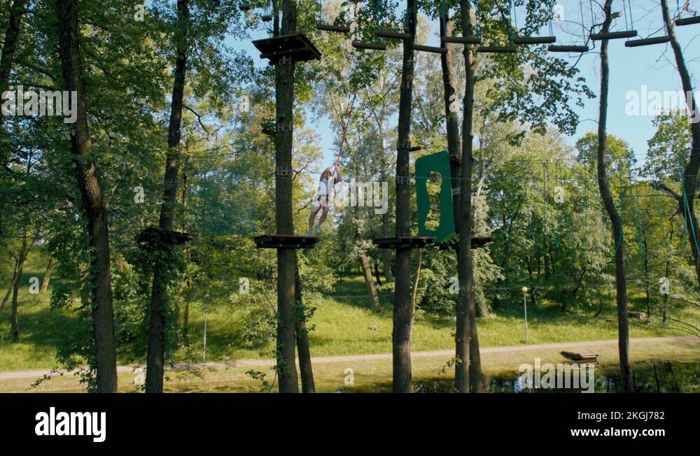 Man in Helmet and Safety System Climbing in Adventure High Rope Park in ...