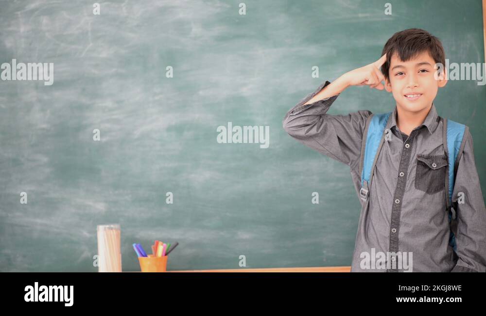 Little boy thinking in front of blackboard in the class room Stock ...