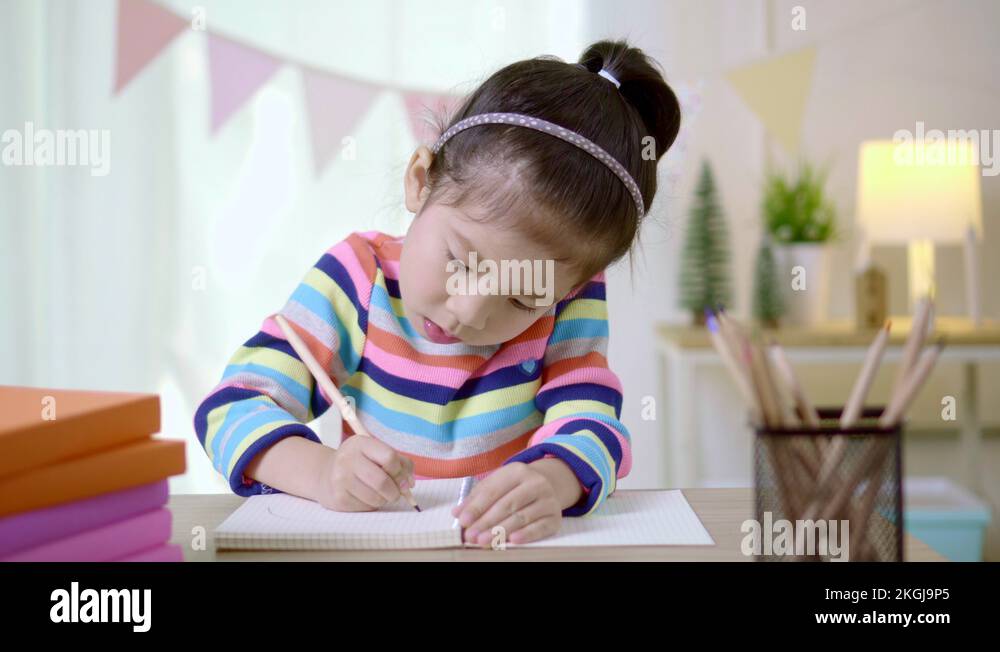 Kid's creativity, Child little asian girl writing in the book on the ...