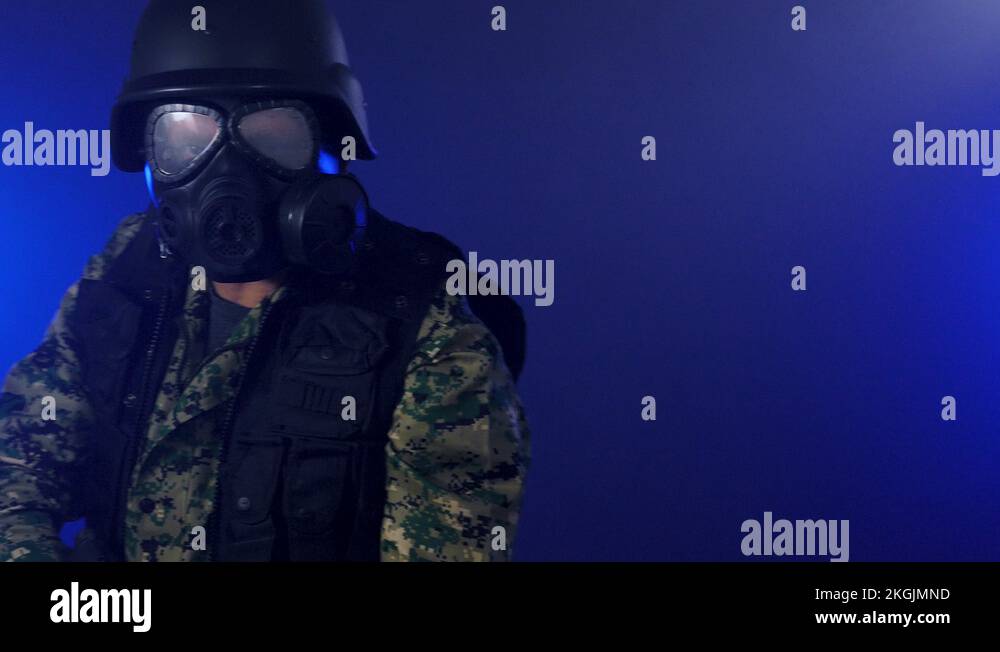 Soldier wearing gas mask moves rifle looking at camera in smoke Stock ...