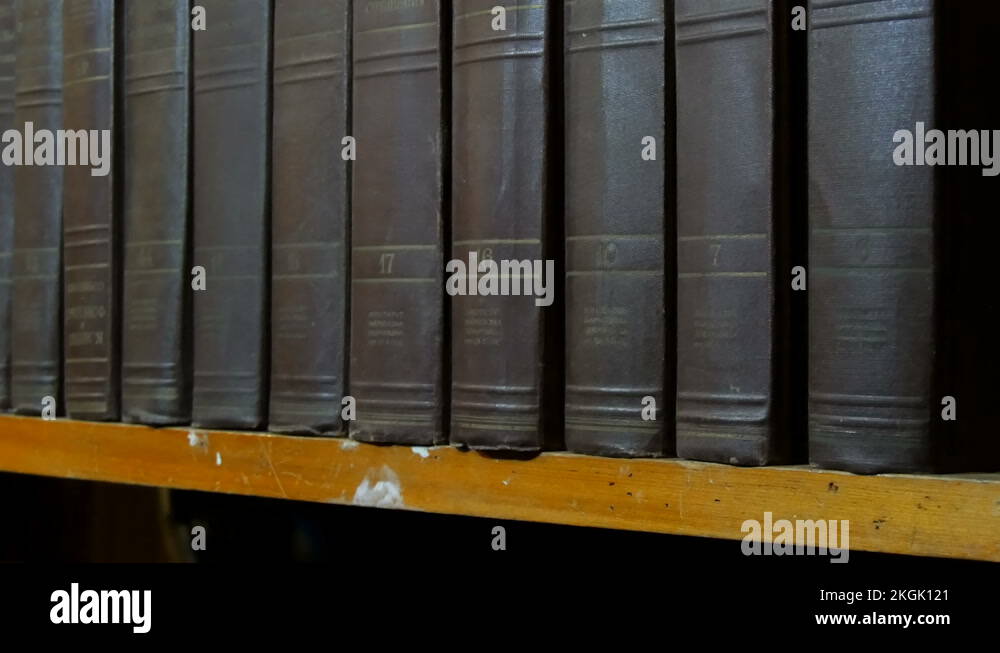 Row of big old black books on a bookshelf in library Stock Video ...
