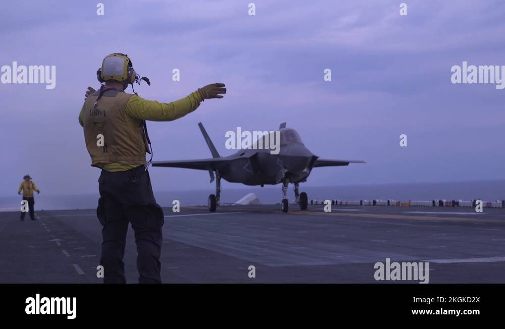Plane director signalling to pilot of F-35B Lightning II aboard USS ...