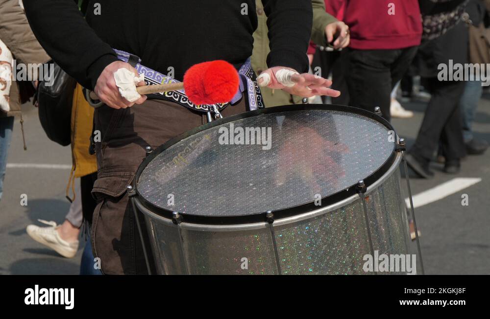 Young man beating on a drum and dancing girls nearby in a street in ...