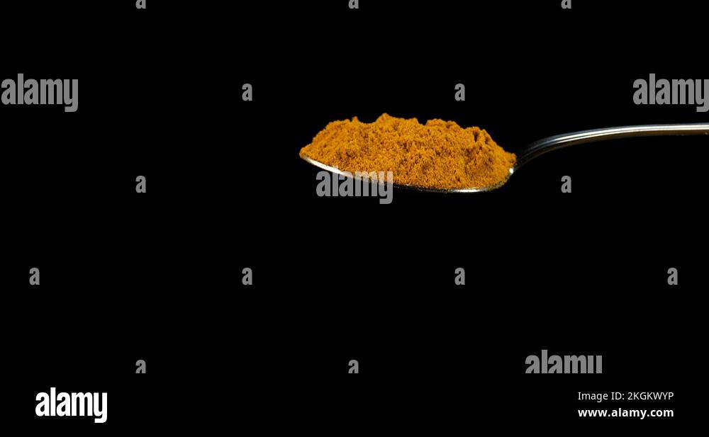 Spoon and Curry Powder falling against Black Background, Slow motion 4K ...
