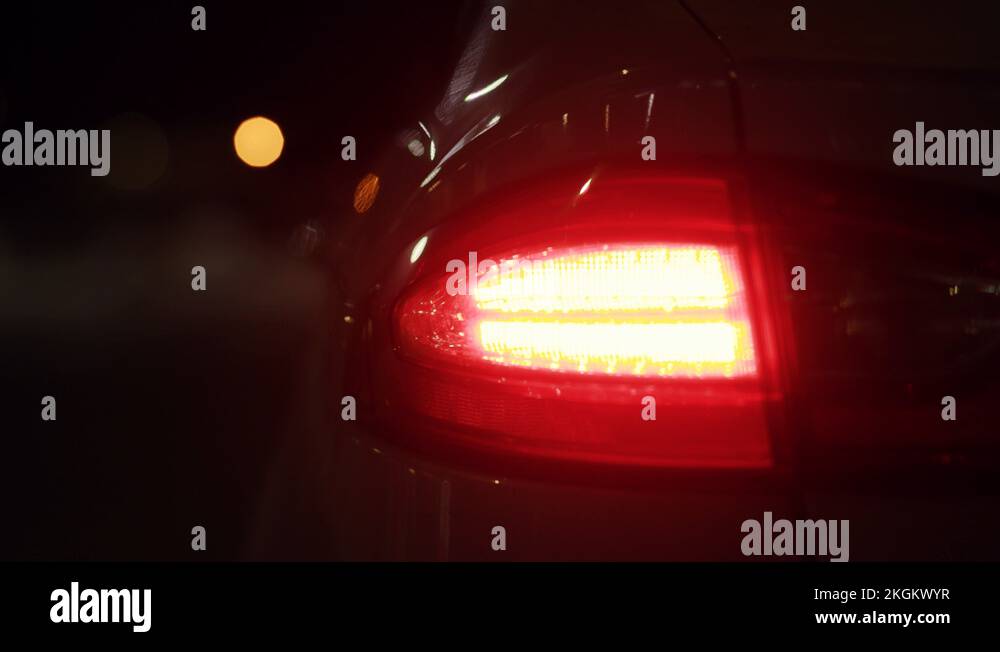 Car detail. New led taillight shining red at night. The rear lights of ...