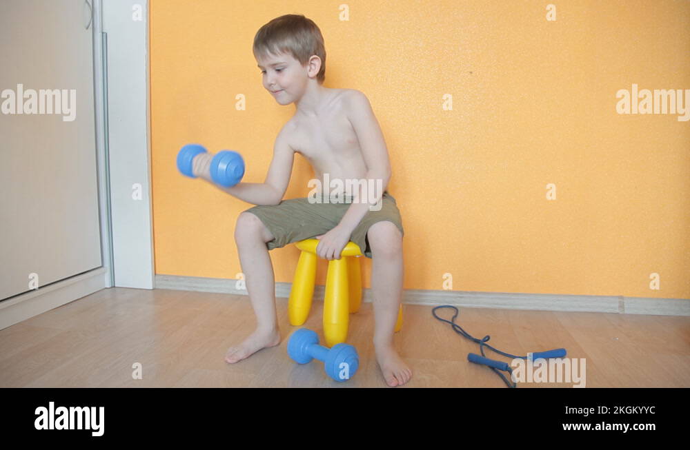 little boy doing dumbbell exercises on biceps, triceps Stock Video ...