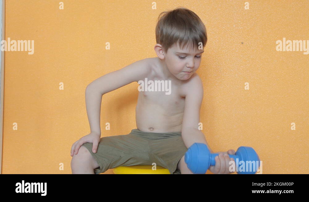 little boy doing dumbbell exercises on biceps, triceps Stock Video ...