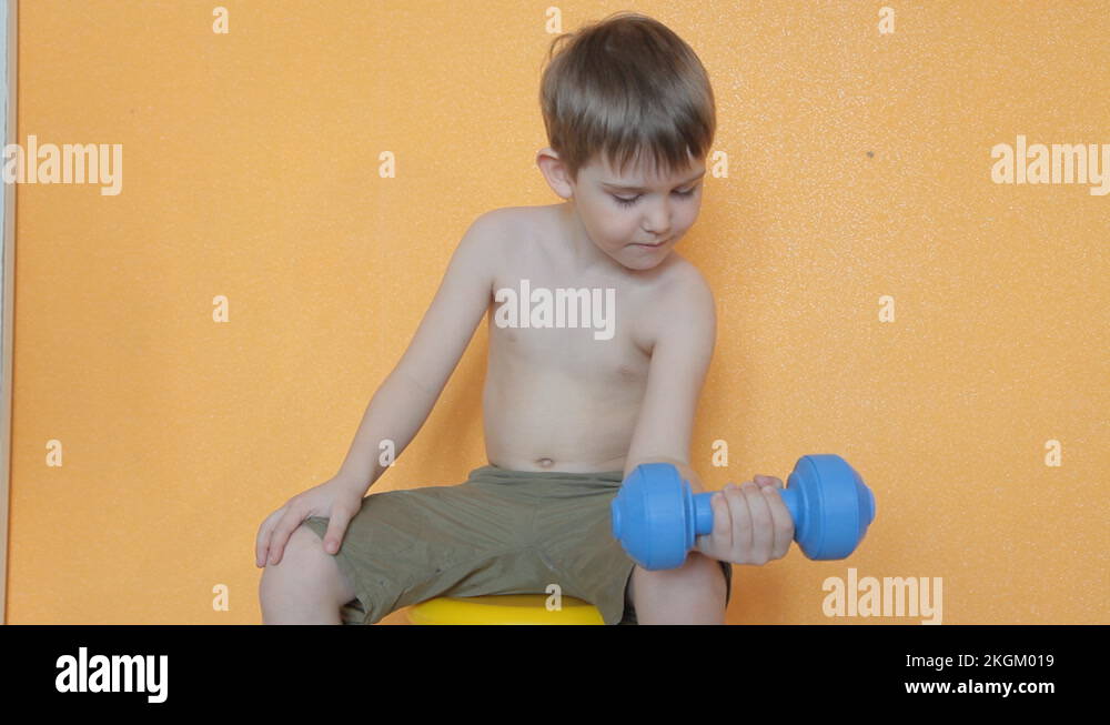 little boy doing dumbbell exercises on biceps, triceps Stock Video ...