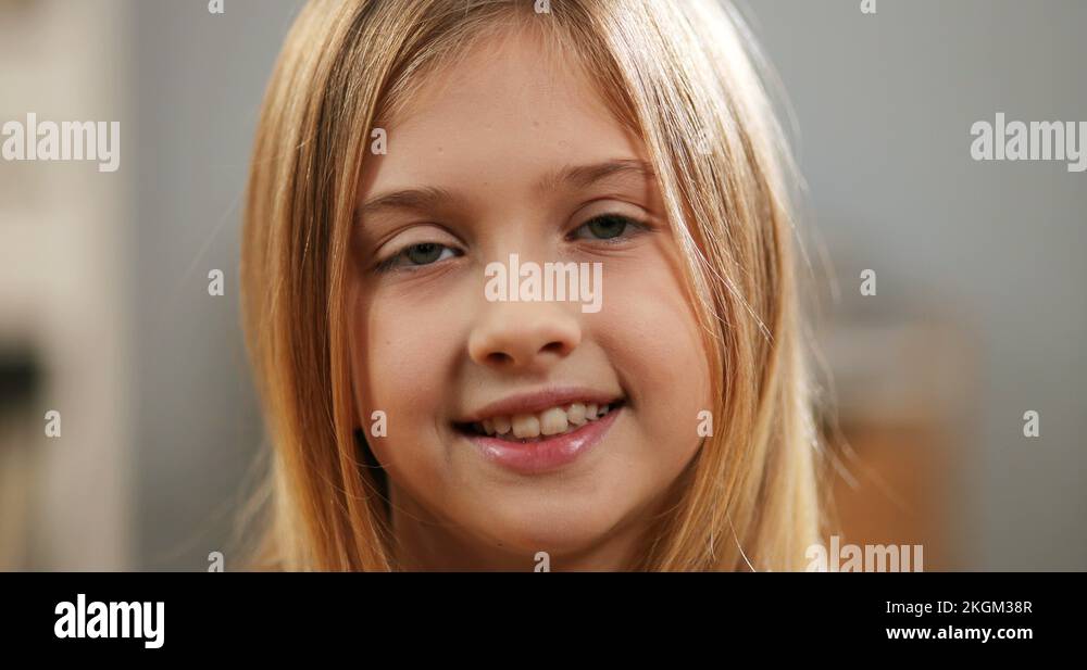 Close up of the face of the pretty blonde Caucasian little girl looking ...