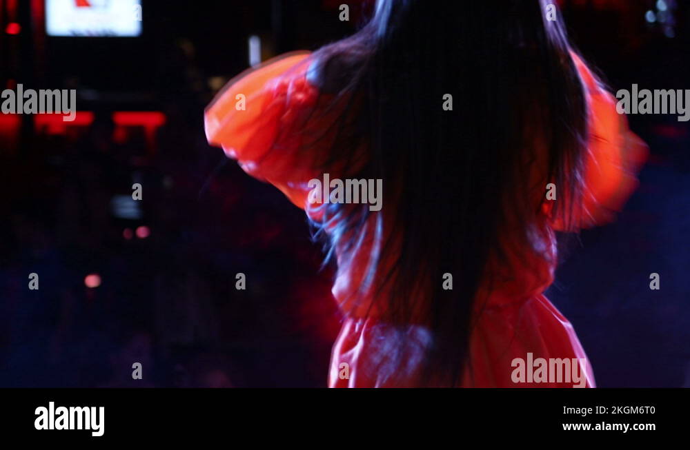 Girl who sings and dances on stage, Back view of singer. Light and ...