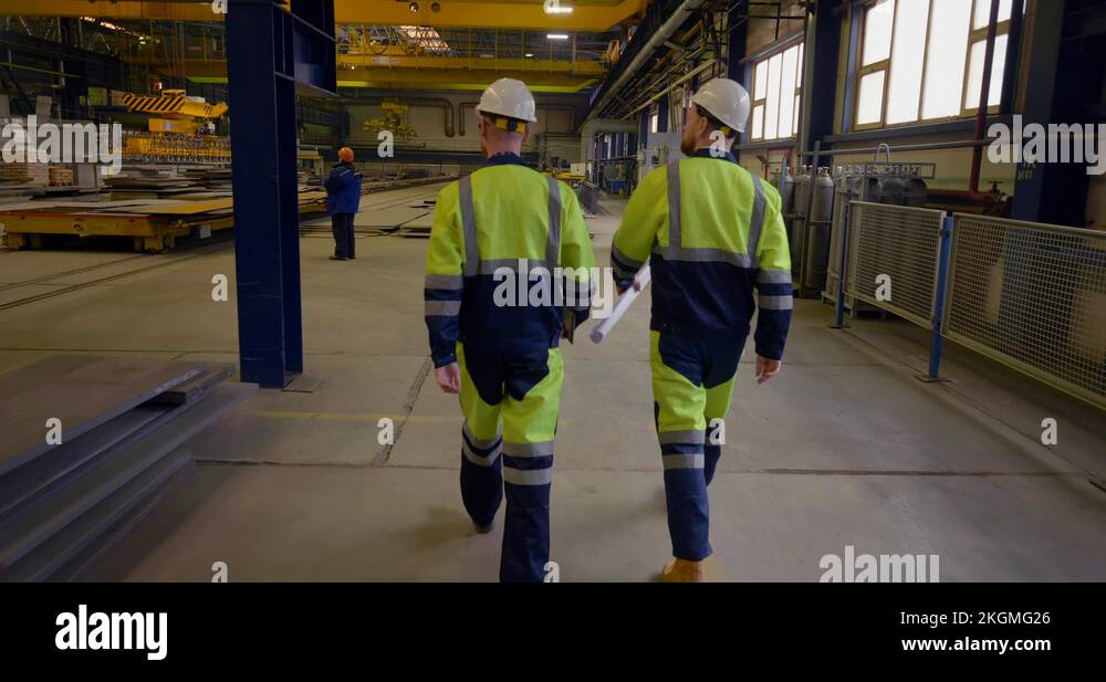 Back view of factory worker giving tour of production workshop Stock ...