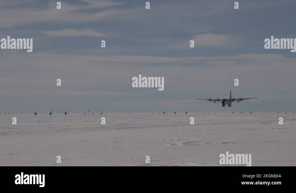 C-130 Hercules fitted with skids flying at low level over snow in ...
