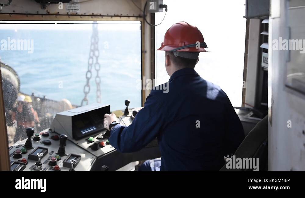 Crew operating crane from control room aboard Coast Guard Cutter Aspen ...