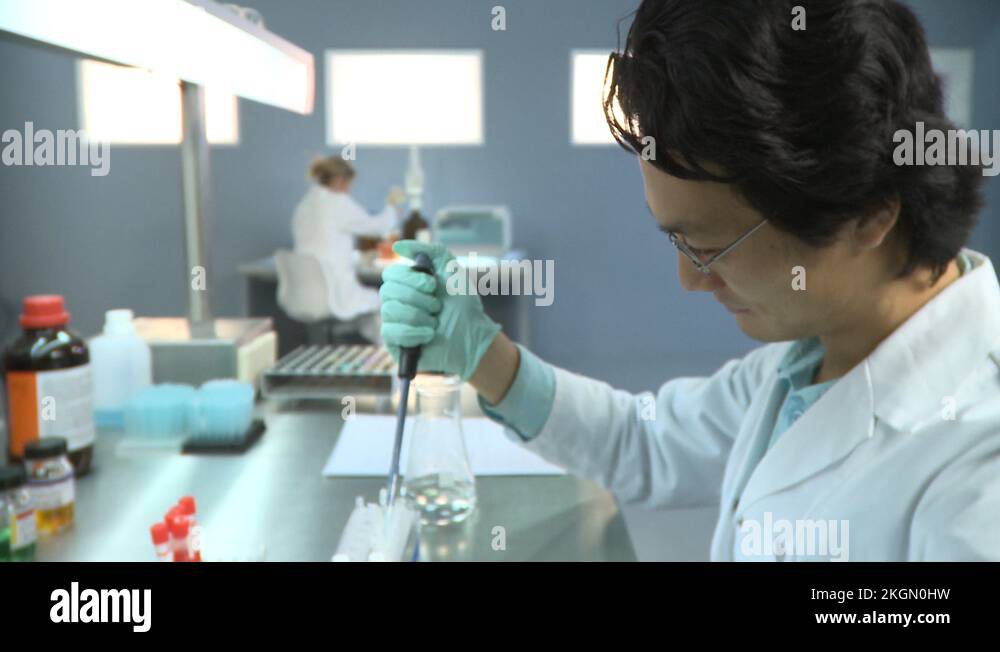 Lockdown, CU, lab tech using a dropper to put samples into vials in a rack Stock Video Footage ...