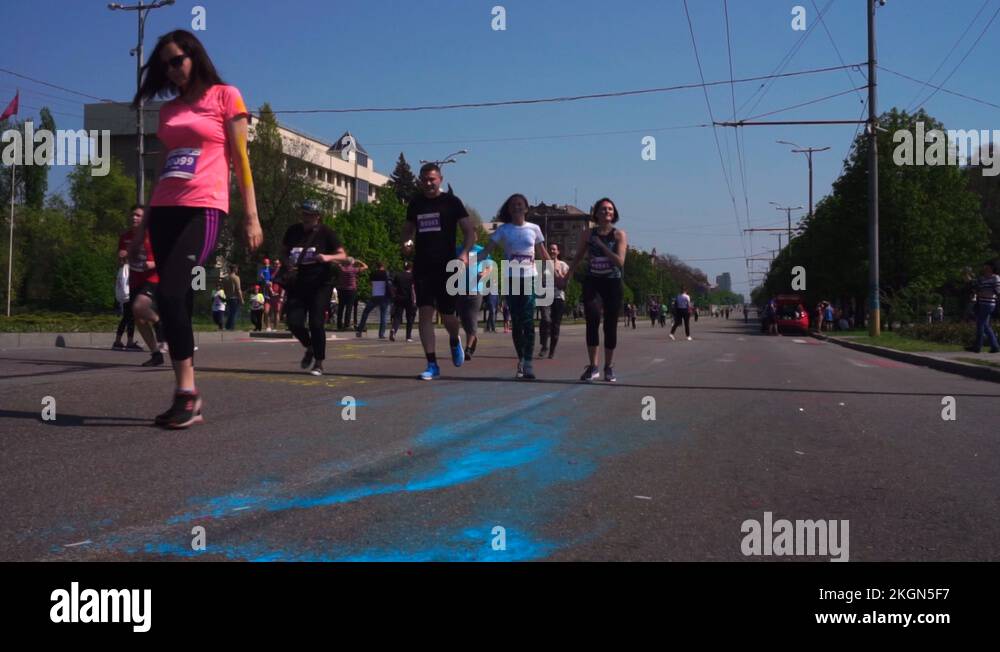 A lot of people run a marathon along the road, along the avenue, along ...