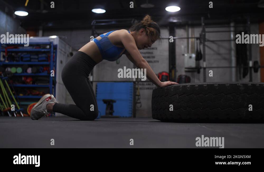 Asian female athletic is keeping doing difficult movements in gym Stock ...