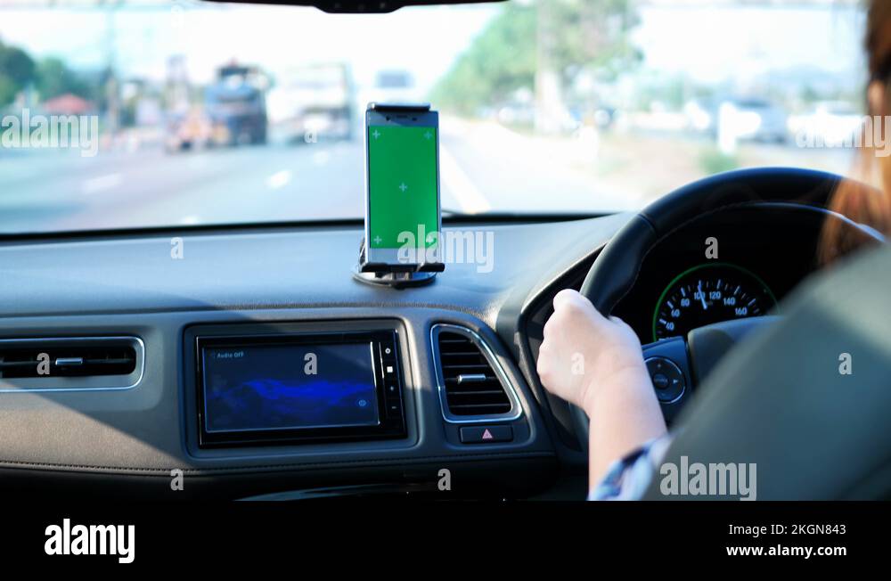 woman driving on the roads and the use of green-screen smart phone. See ...