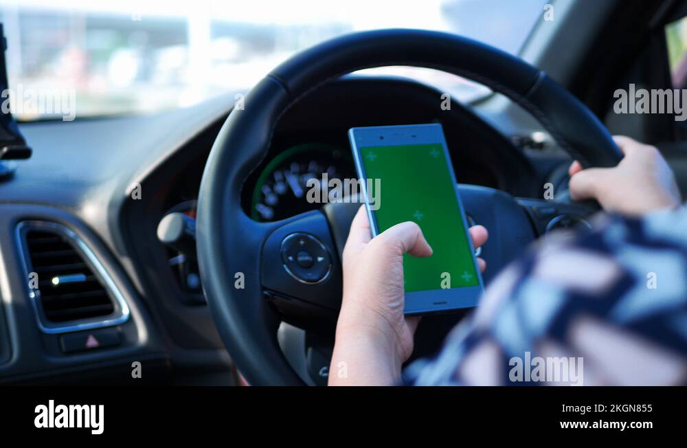 woman driving on the roads and the use of green-screen smart phone. See ...